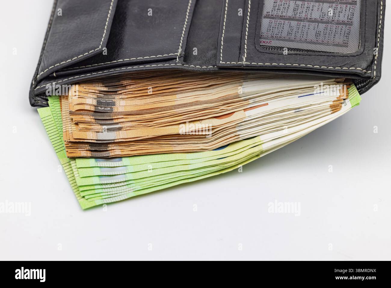 A black purse is overflowing with euro banknotes and banknotes Stock ...