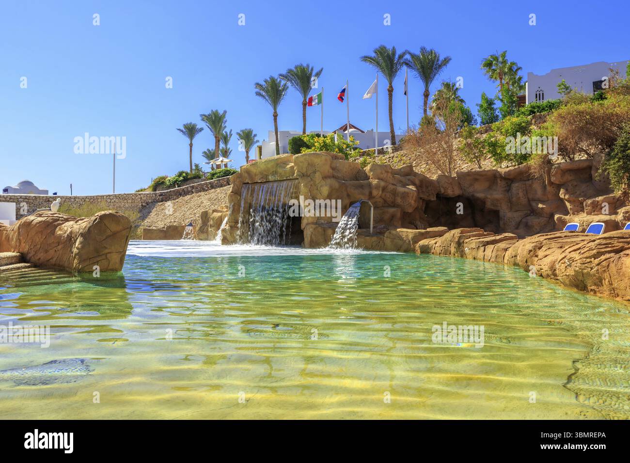 The view at beautiful swimming pool at the luxury hotel and palm trees ...