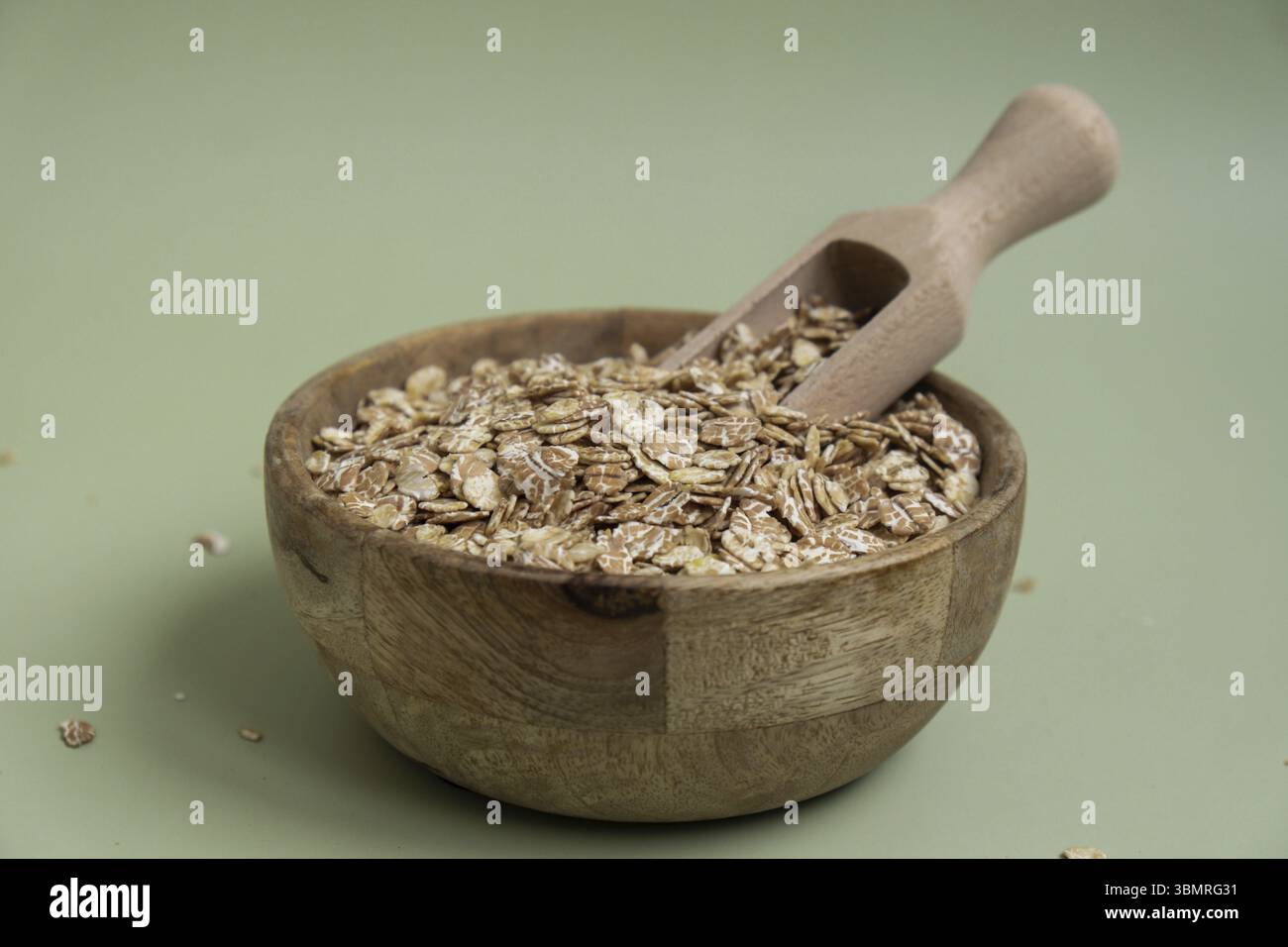 Raw oatmeal porridge in green background copy space. Whole spelt grain ...