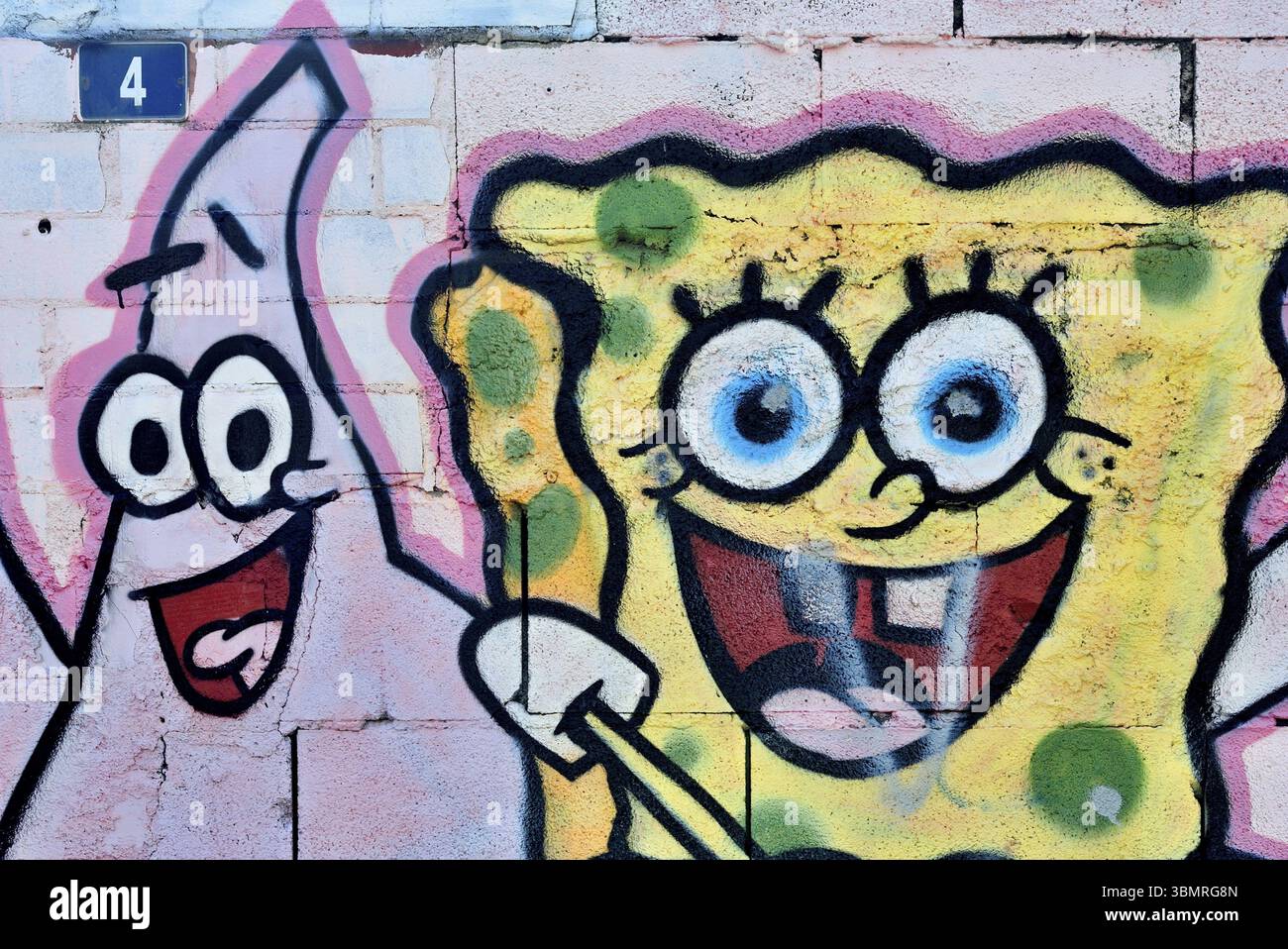 Spongebob and Patrick are depicted in a colorful graffiti on a brick ...