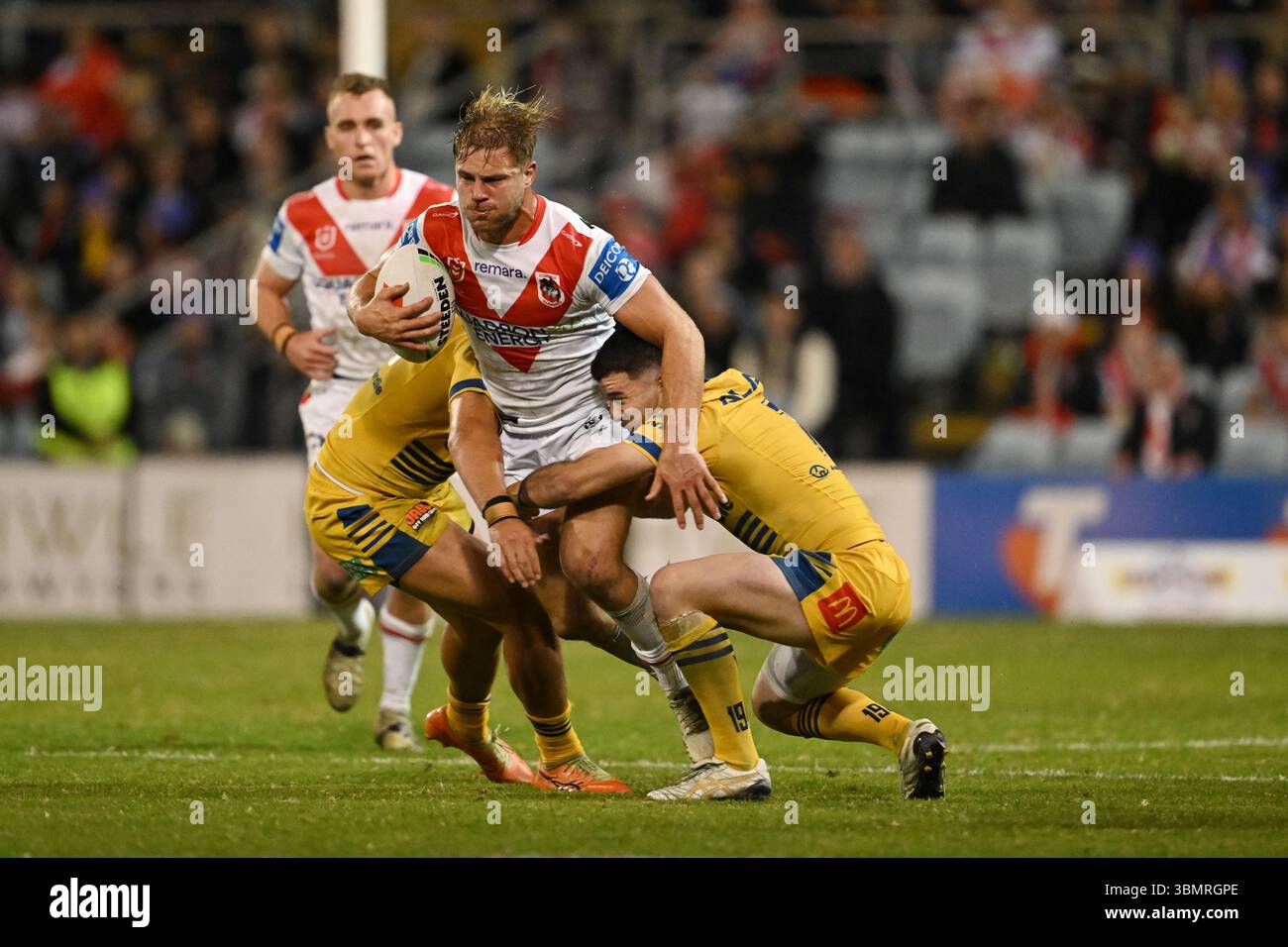 Jack De Belin of the Dragons is tackled by Dean Hawkins of the Eels ...