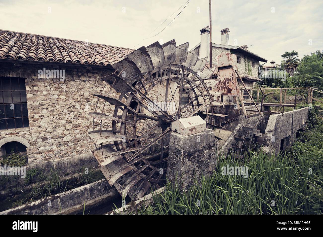 Old water mill with iron water wheel. Photo in vintage style Stock ...