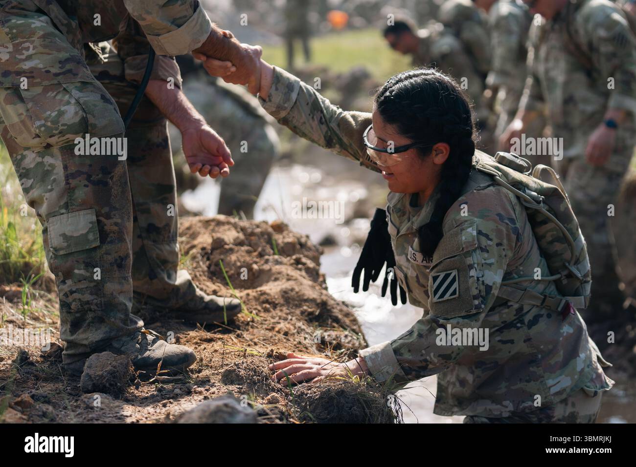 A U.S. Soldier assigned to 3rd Infantry Division, pulls another Soldier ...