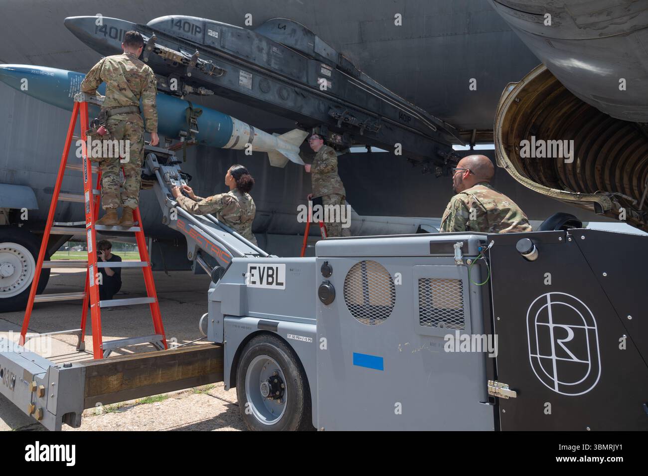 Airmen from the 702nd Maintenance Squadron load an inert munition onto ...