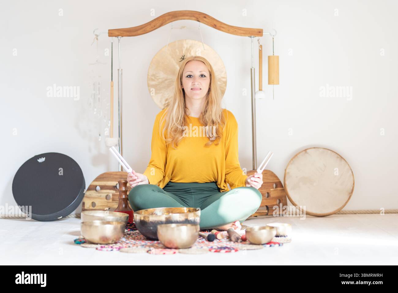 Young cheerful woman performing music therapy session with traditional ...