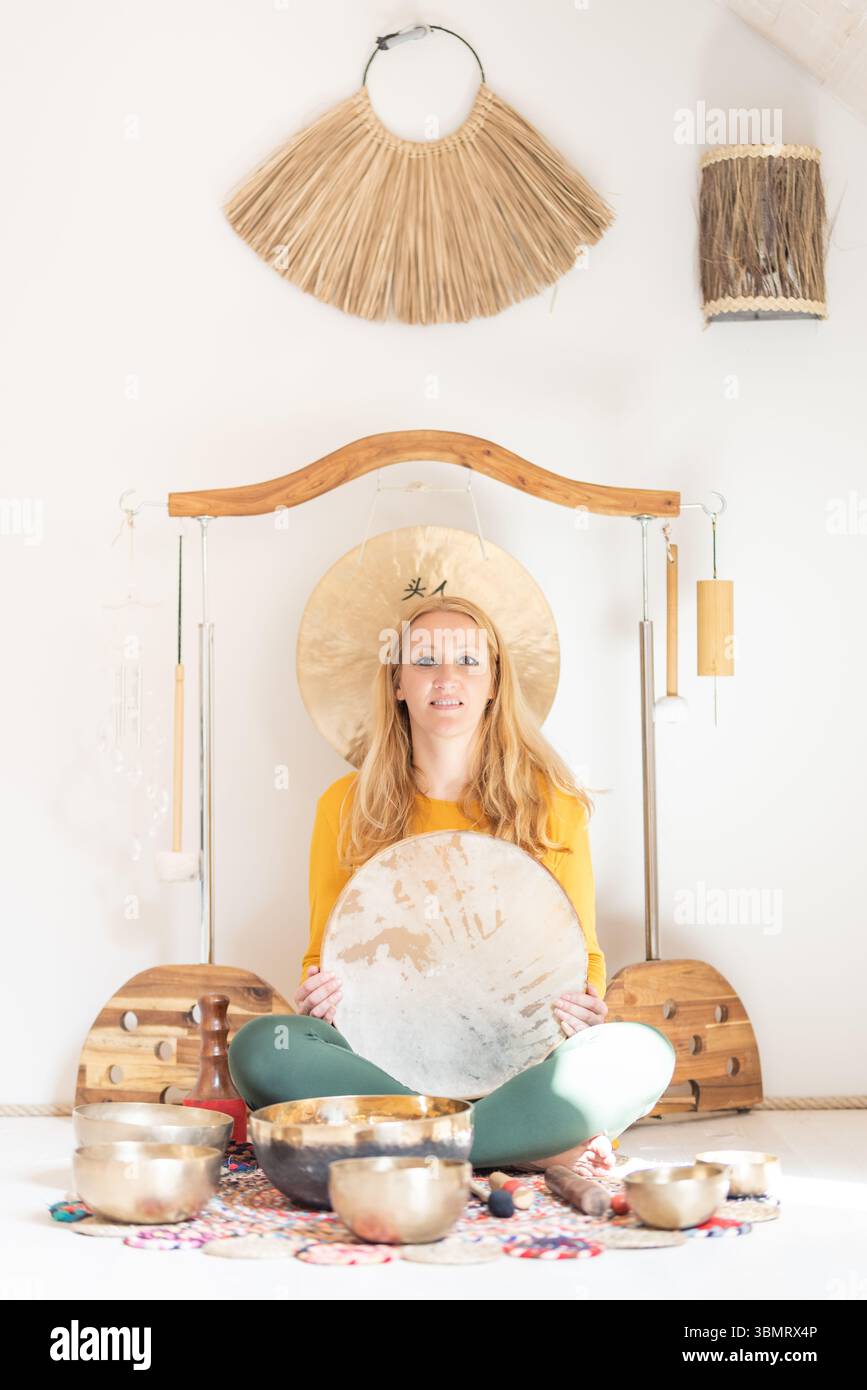Young cheerful woman performing music therapy session with traditional ...