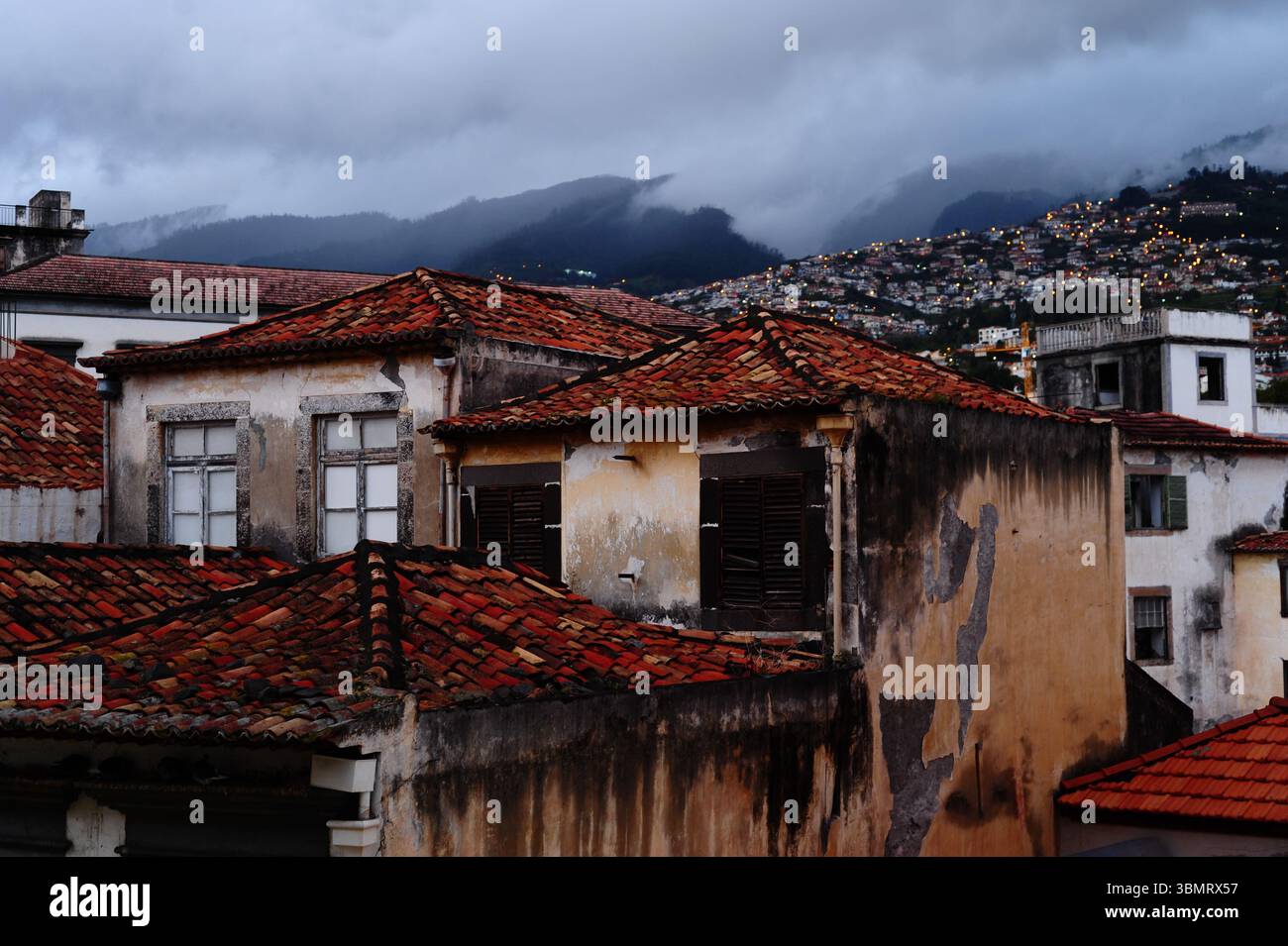Old buildings in the city of Funchal, Madeira, with dark rain clouds ...