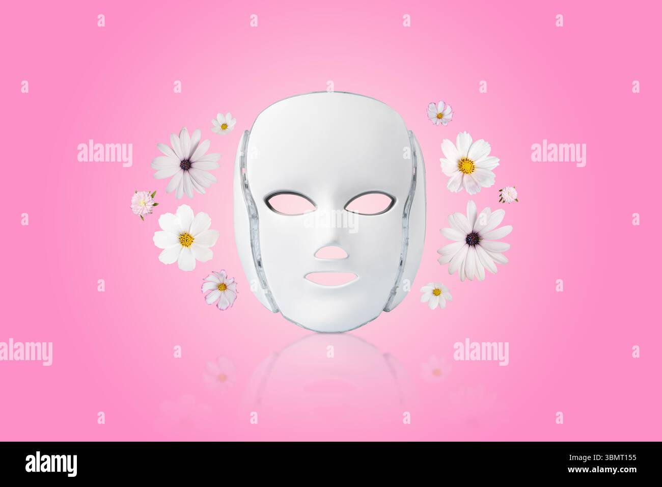 Cosmetic LED facial mask regenerative treatment on pink background with ...