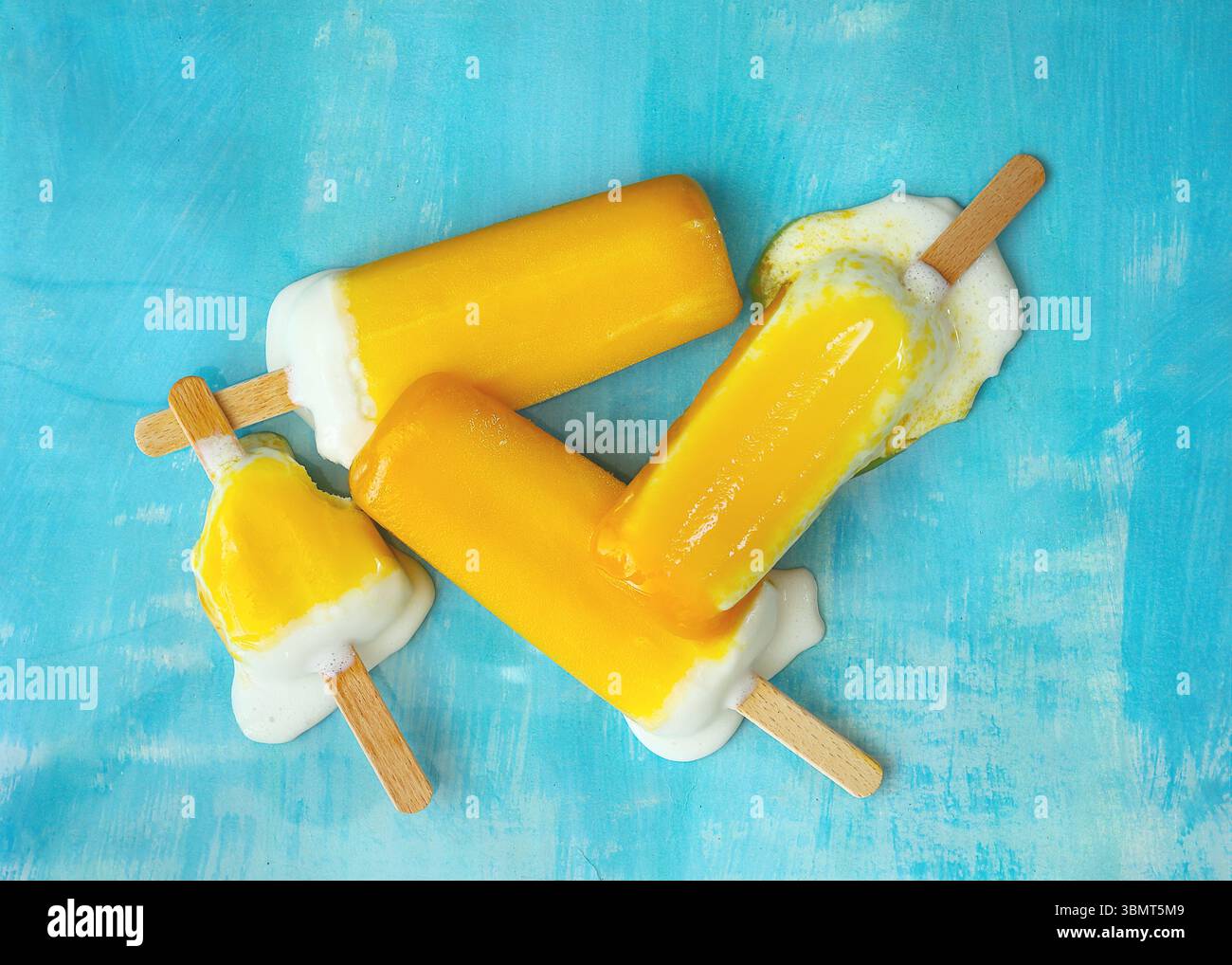 A melting popsicle with a wooden stick showing vibrant yellow color on ...