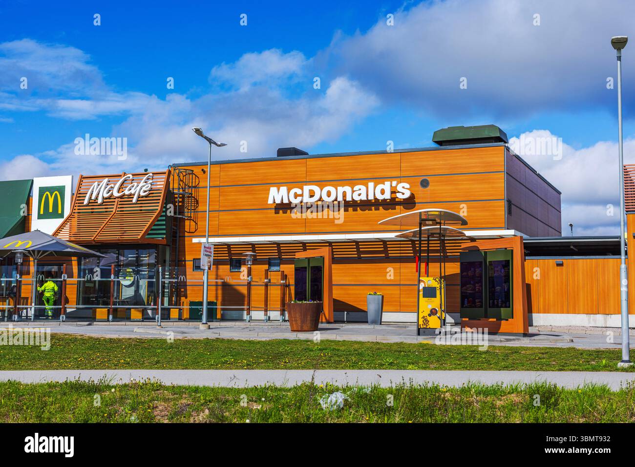 Modern McDonald’s building with McCafe and drive-thru kiosk under blue ...