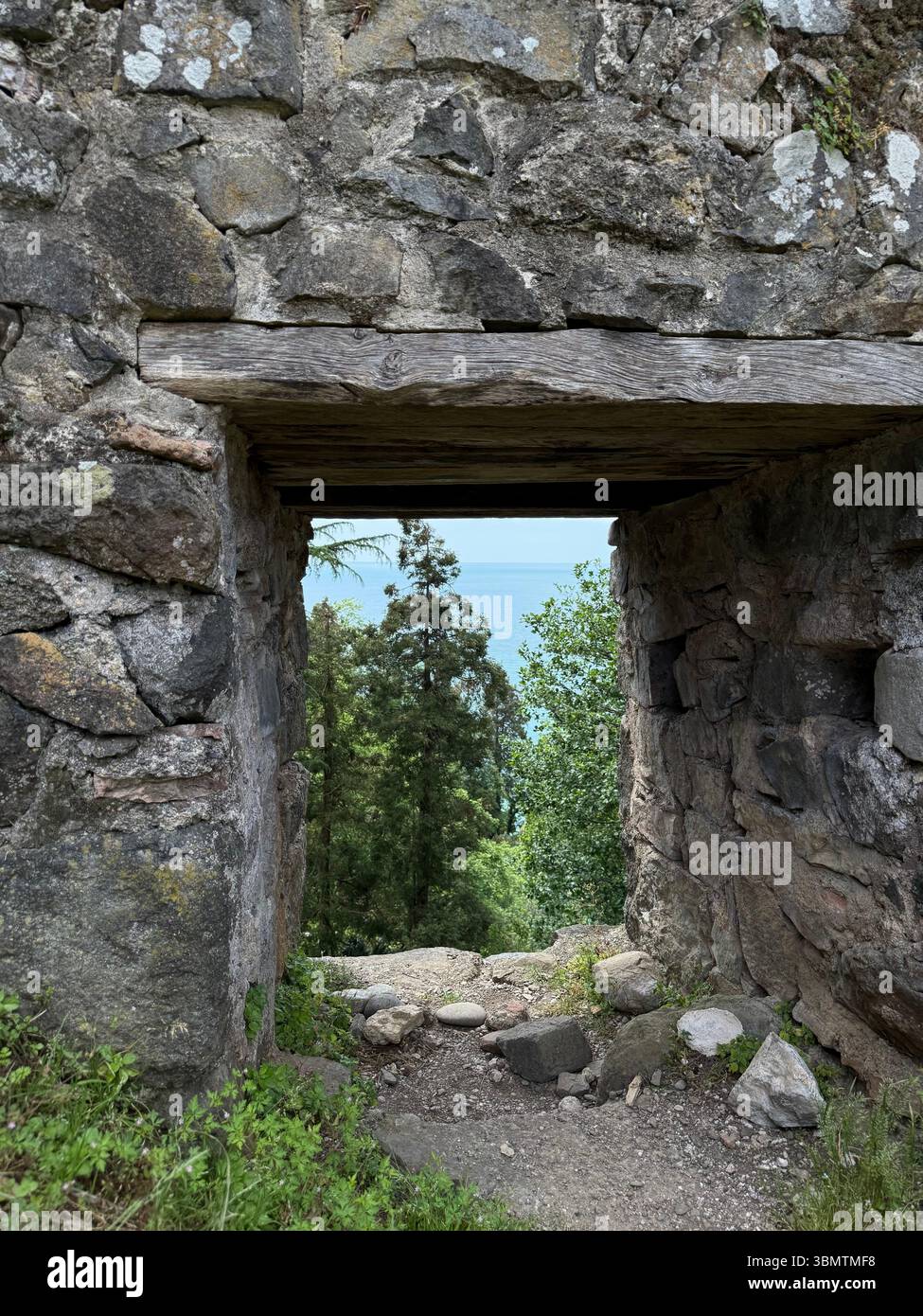 This photo shows a rectangular stone doorway built into a historic wall ...