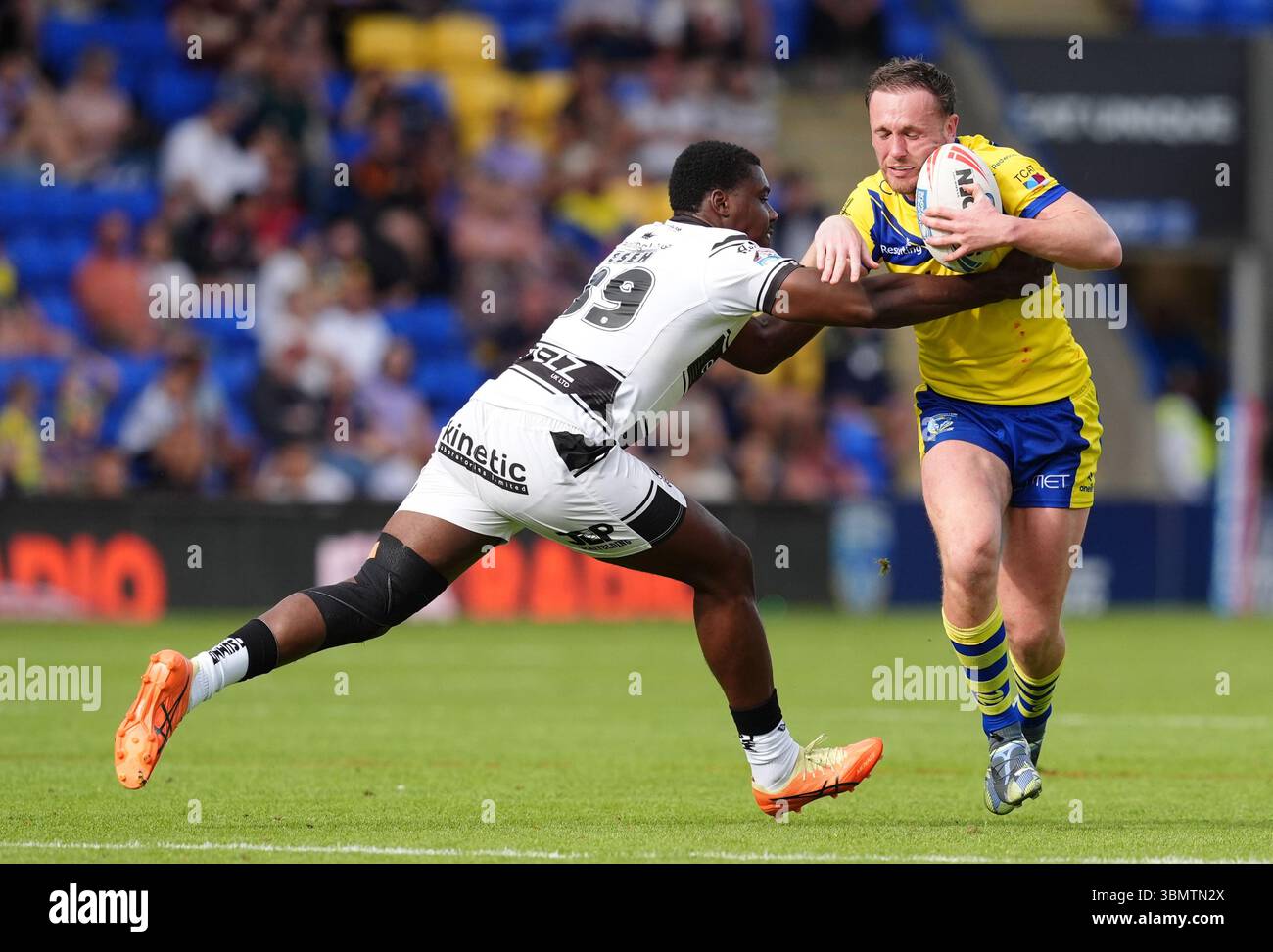 Warrington Wolves' Ben Currie (right) tackled by Hull FC's Sam Eseh ...
