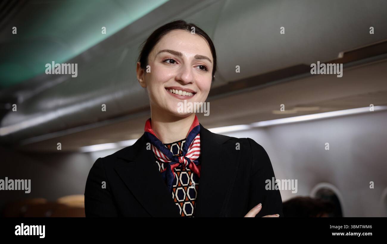 Air hostess. Smiling flight attendant in uniform welcomes and guides ...