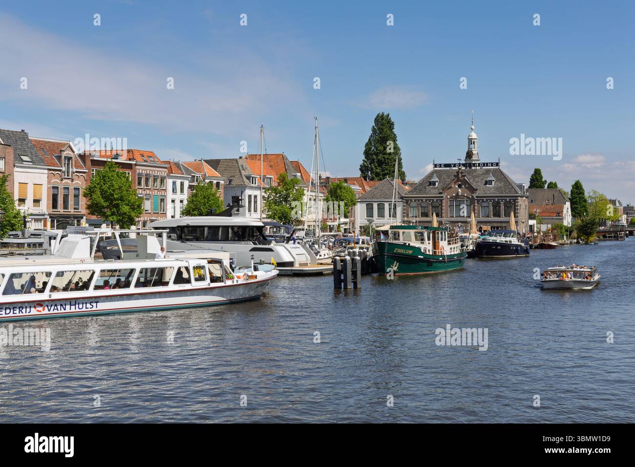 Sunny canal scene in Leiden, featuring historic buildings, boats, and a ...
