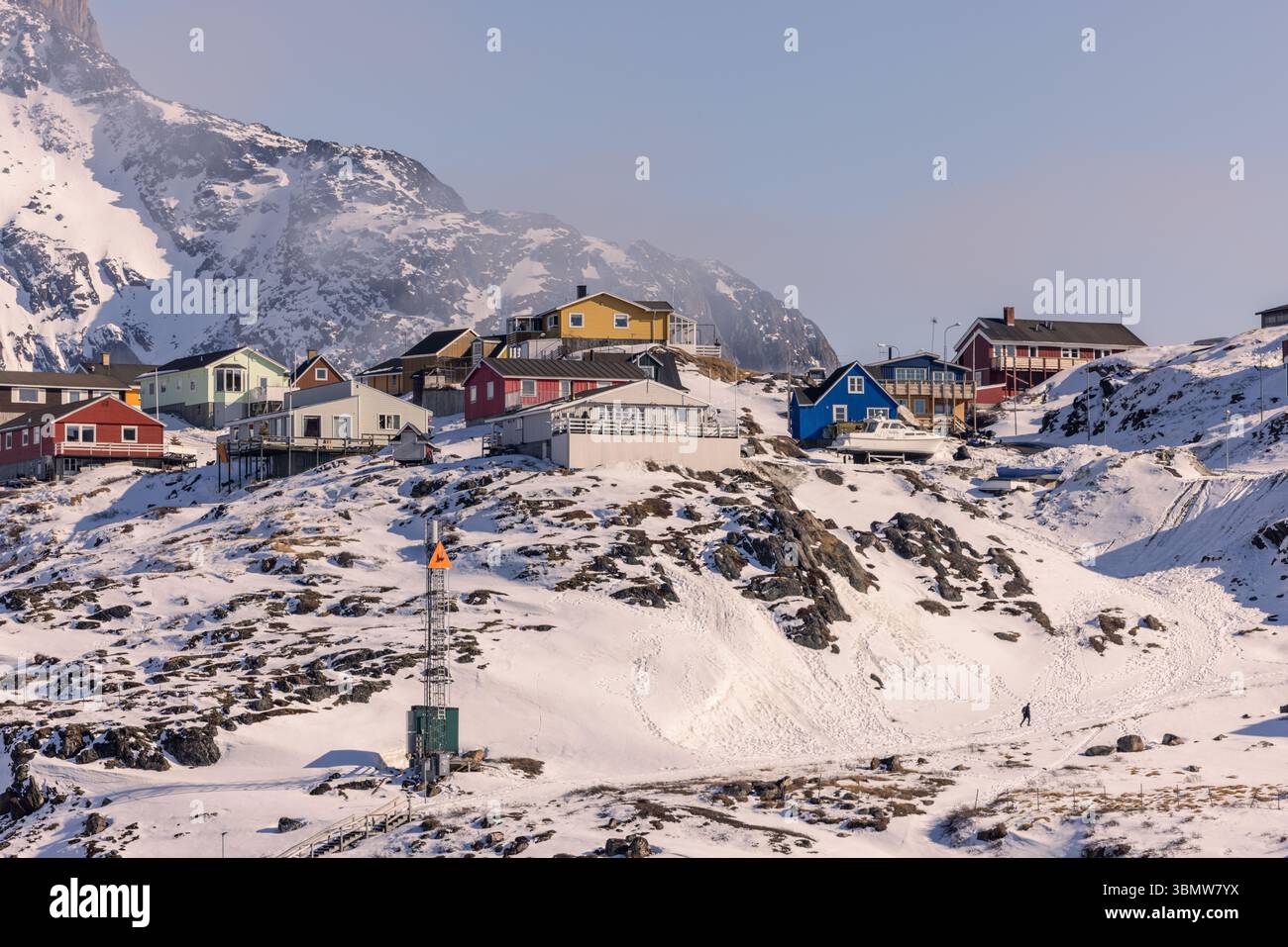 Bright wooden houses on a snowy slope in Sisimiut, Greenland, with ...