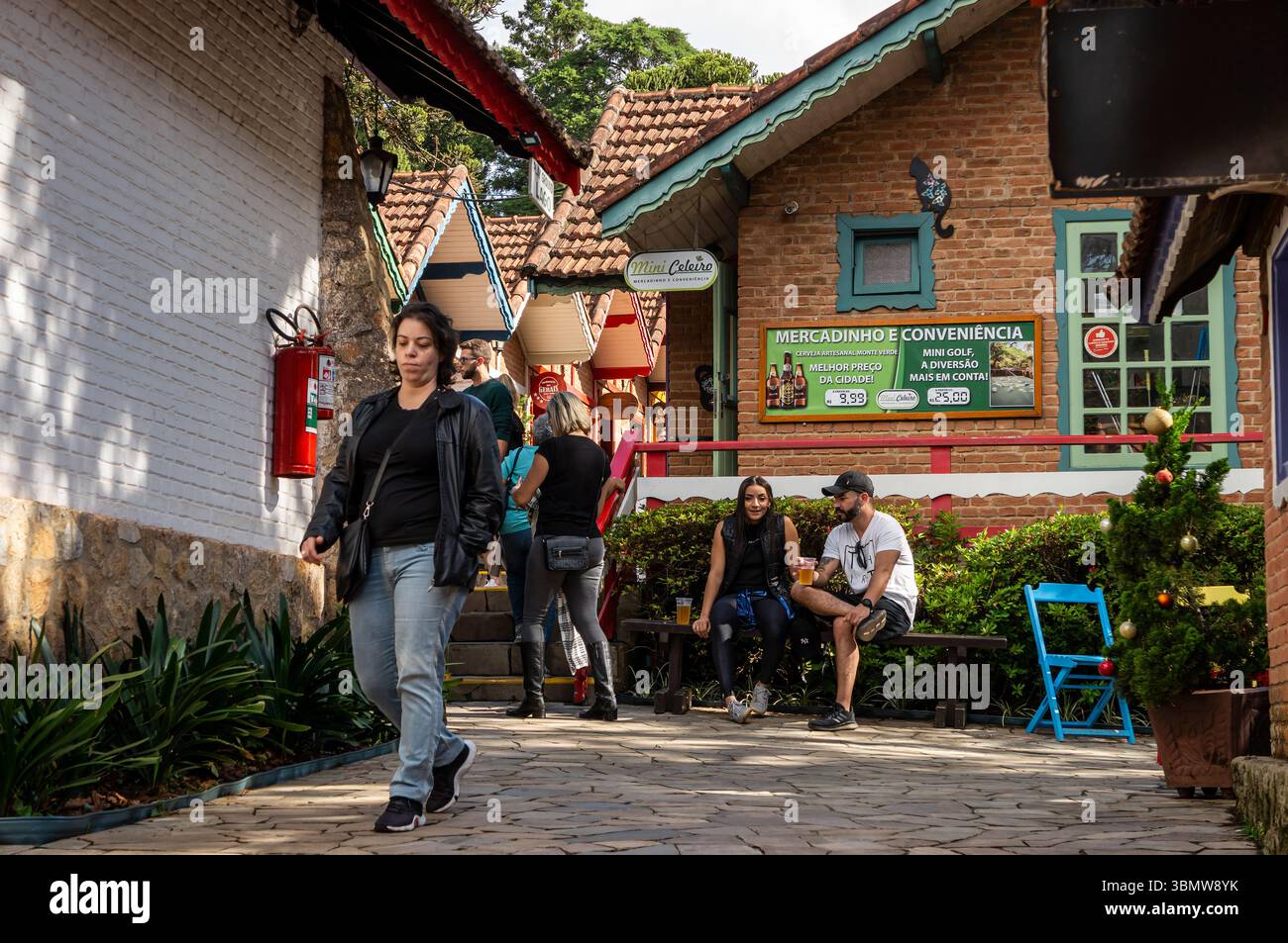 People relax and stroll past Mini Celeiro convenience store in the ...