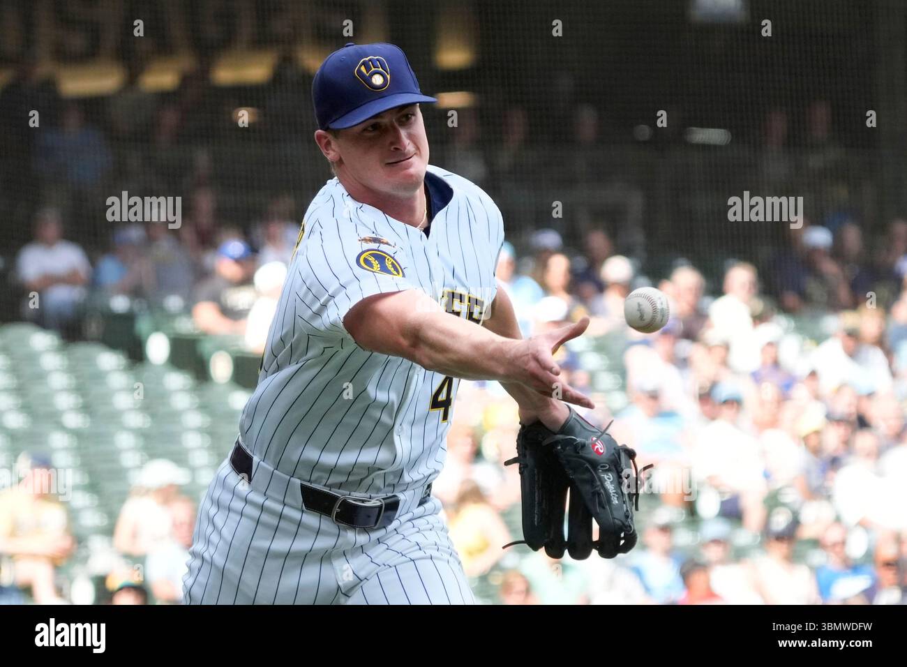 Milwaukee Brewers pitcher Quinn Priester tosses the ball to first base ...
