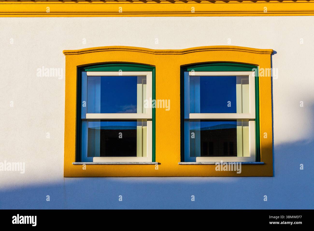 A brightly colored yellow and green window frame with two modern ...