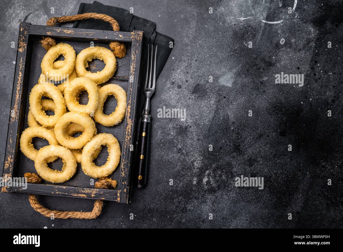 Raw squid rings with breading, uncooked calamari snack. black ...