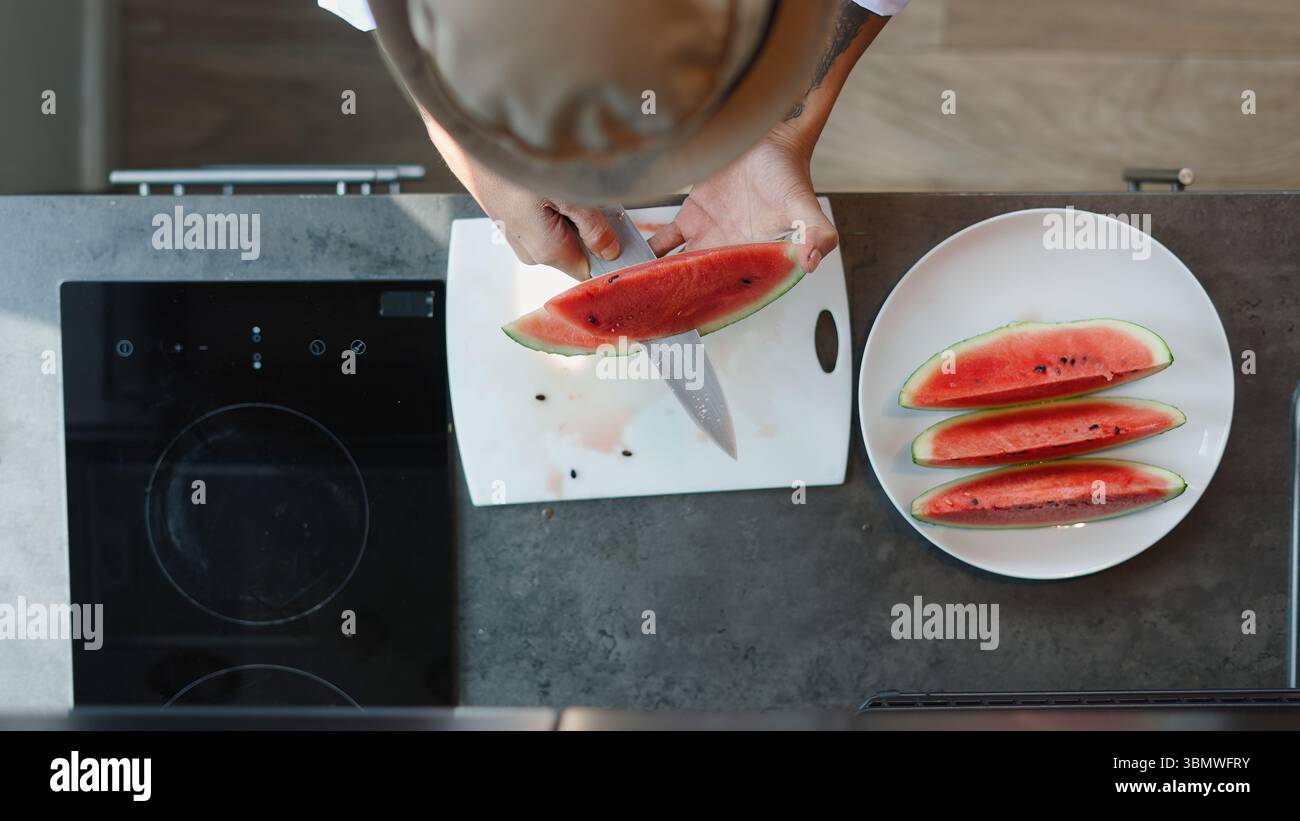 Chef slicing watermelon on white cutting board, creating fresh summer ...