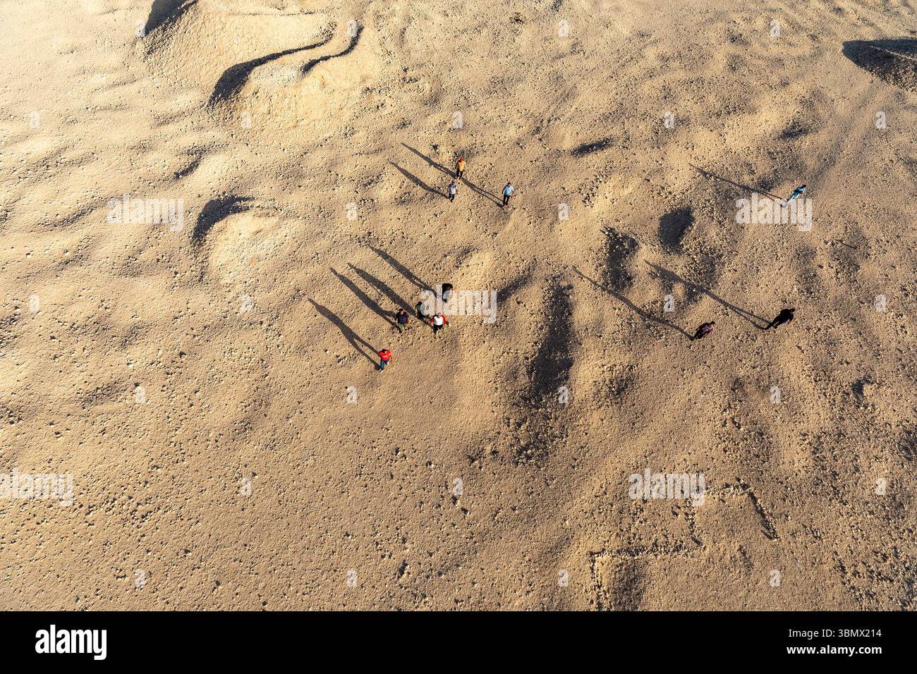 Aerial view of group of men standing in the desert dunes Stock Photo ...