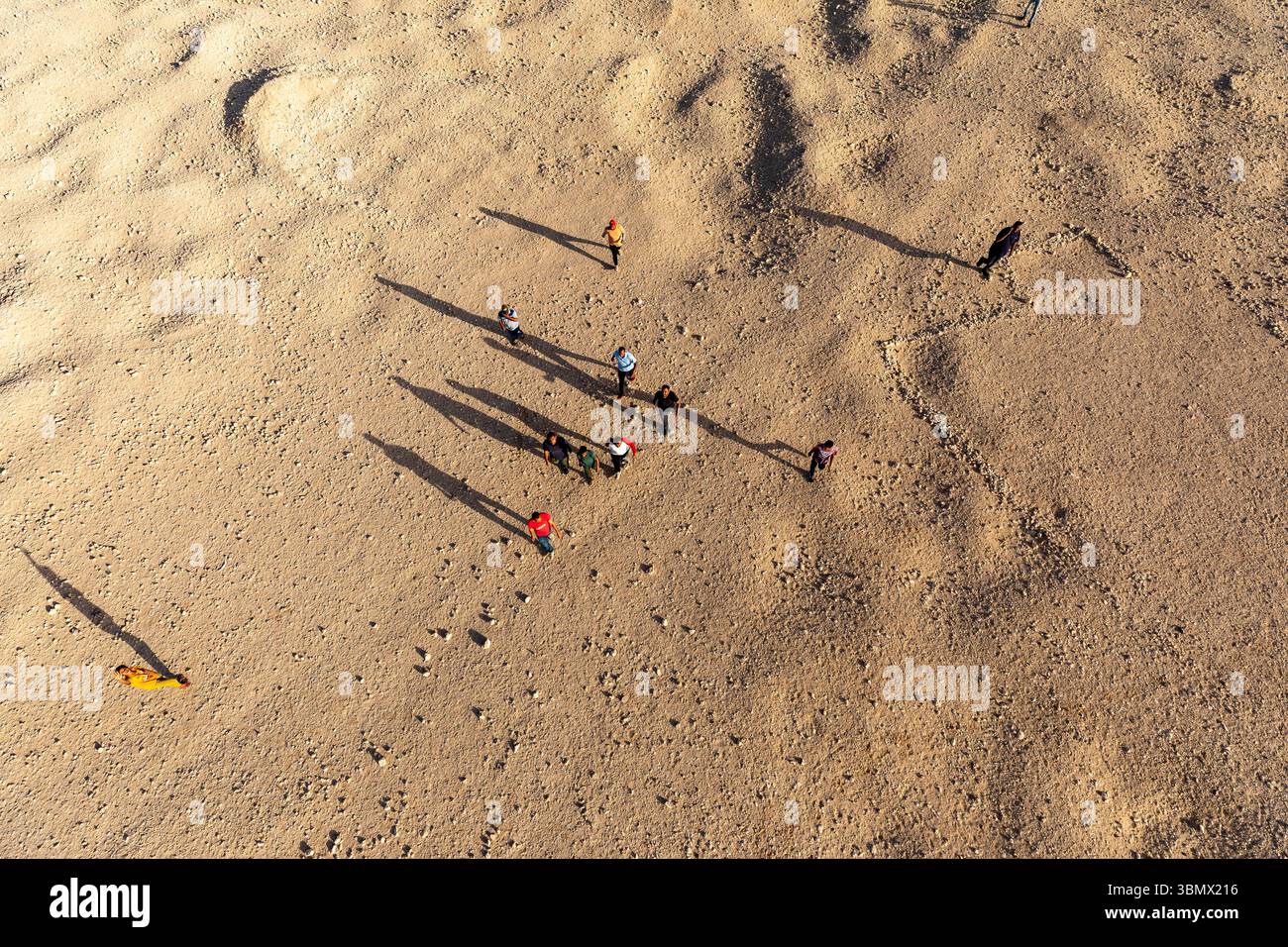 Aerial view of group of men standing in the desert dunes Stock Photo ...