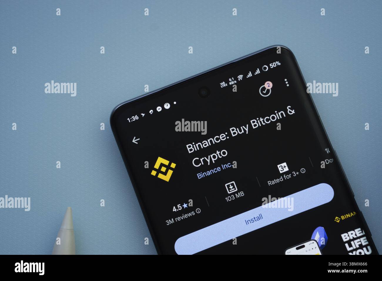Dhaka, Bangladesh- 29 May 2025: On a blue surface, a smartphone displays the binance app within ...