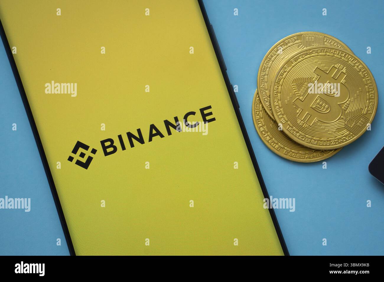 Dhaka, Bangladesh- 22 June 2025: Binance logo on smartphone screen near Bitcoin coin and QR code ...