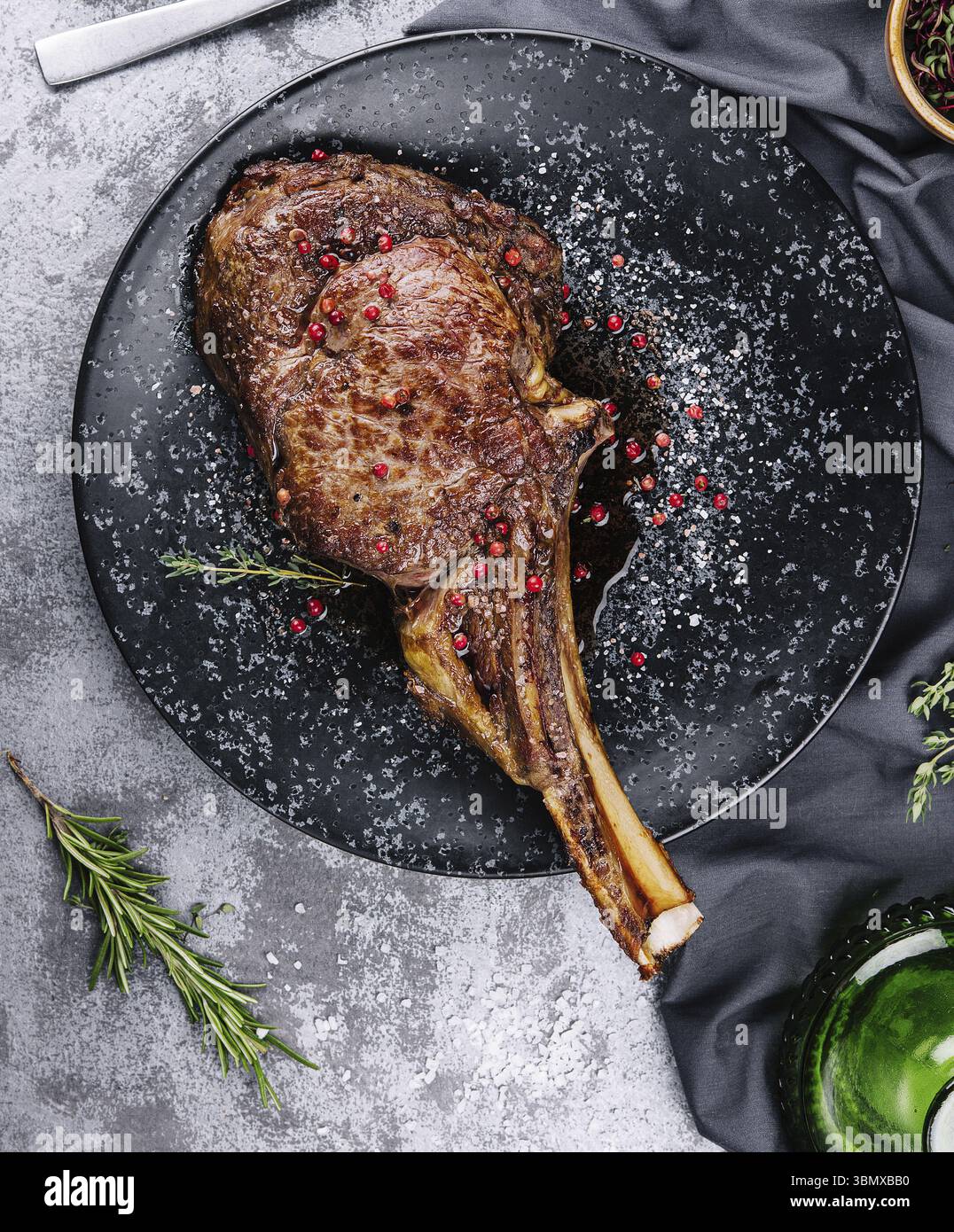 food still-life, Grilled pork steak with bone in sauce on black plate ...