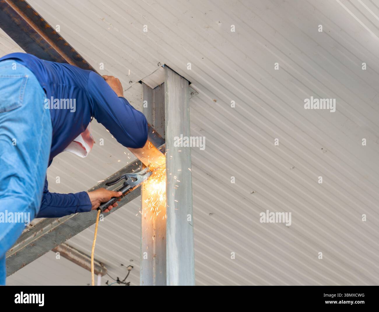 A worker is performing welding work on steel supports for the main ...