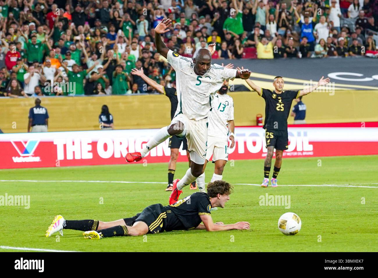 Saudi Arabia defender Abdullah Madu (5) jumps over Mexico forward ...