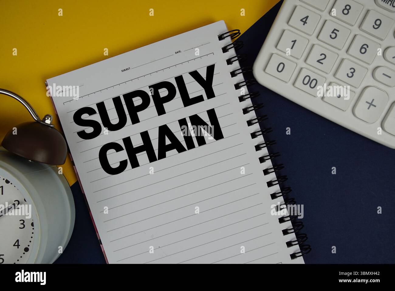 Supply chain text written on notepad with calculator and alarm clock on ...