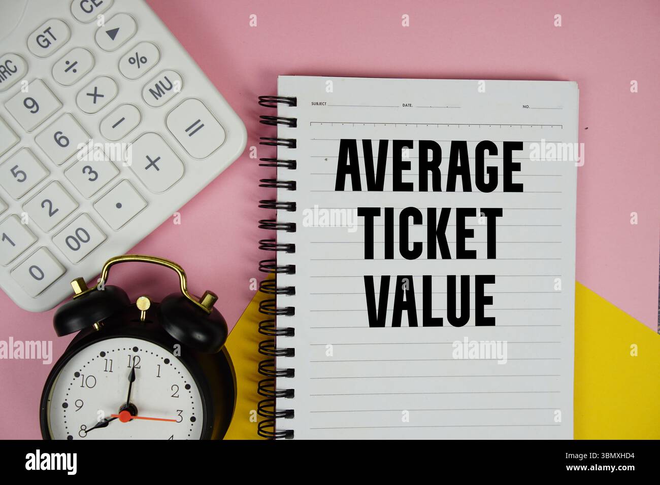 Average Ticket Value text written on notepad with calculator and alarm ...
