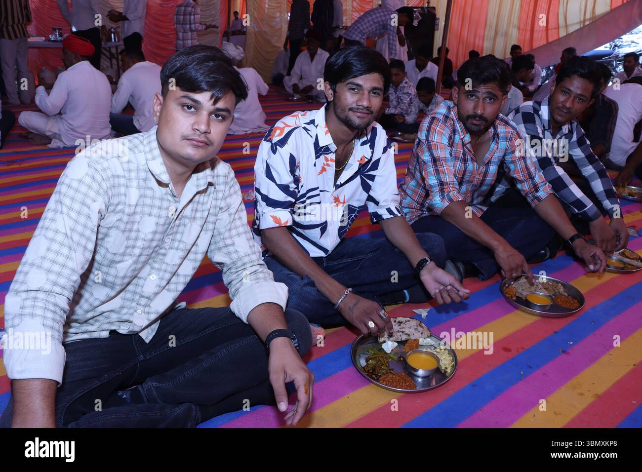 Four young Indian men eating food at a wedding reception Stock Photo ...