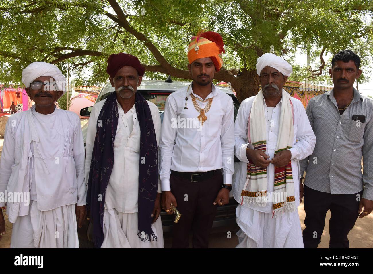 Group of Indian rural men in traditional attire standing outdoors under ...
