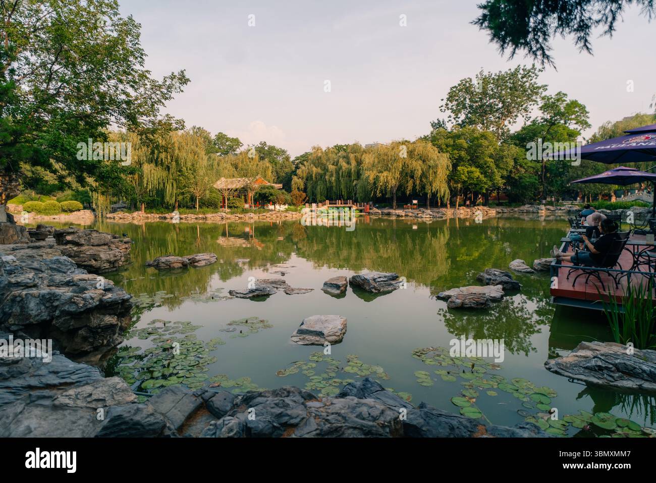 Ornate pavilion mirrored in a lake of the historical Ritan Park which ...