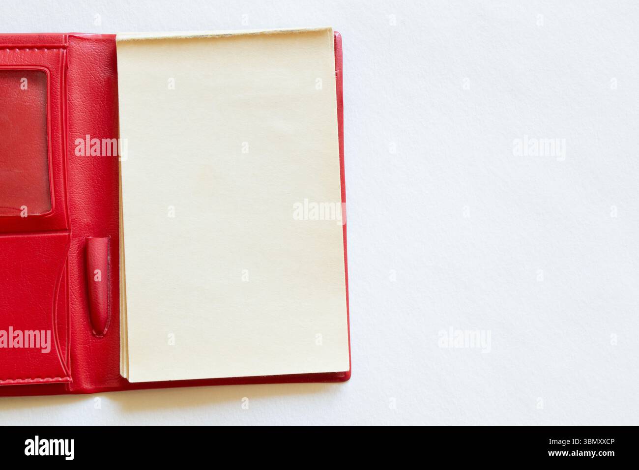 Open notebook with blank page in red cover on white background, top ...