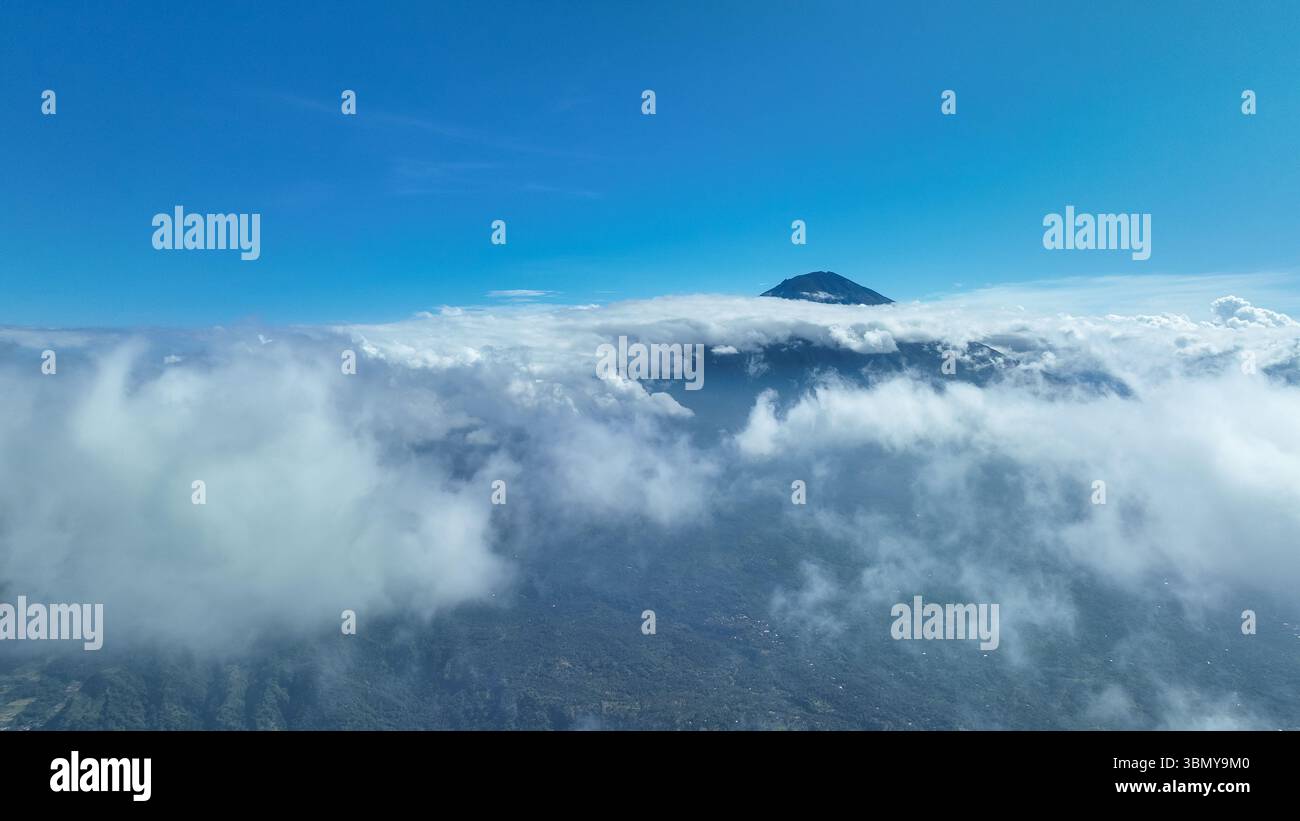 The summit of Gunung Agung pierces through a sea of clouds, revealing ...
