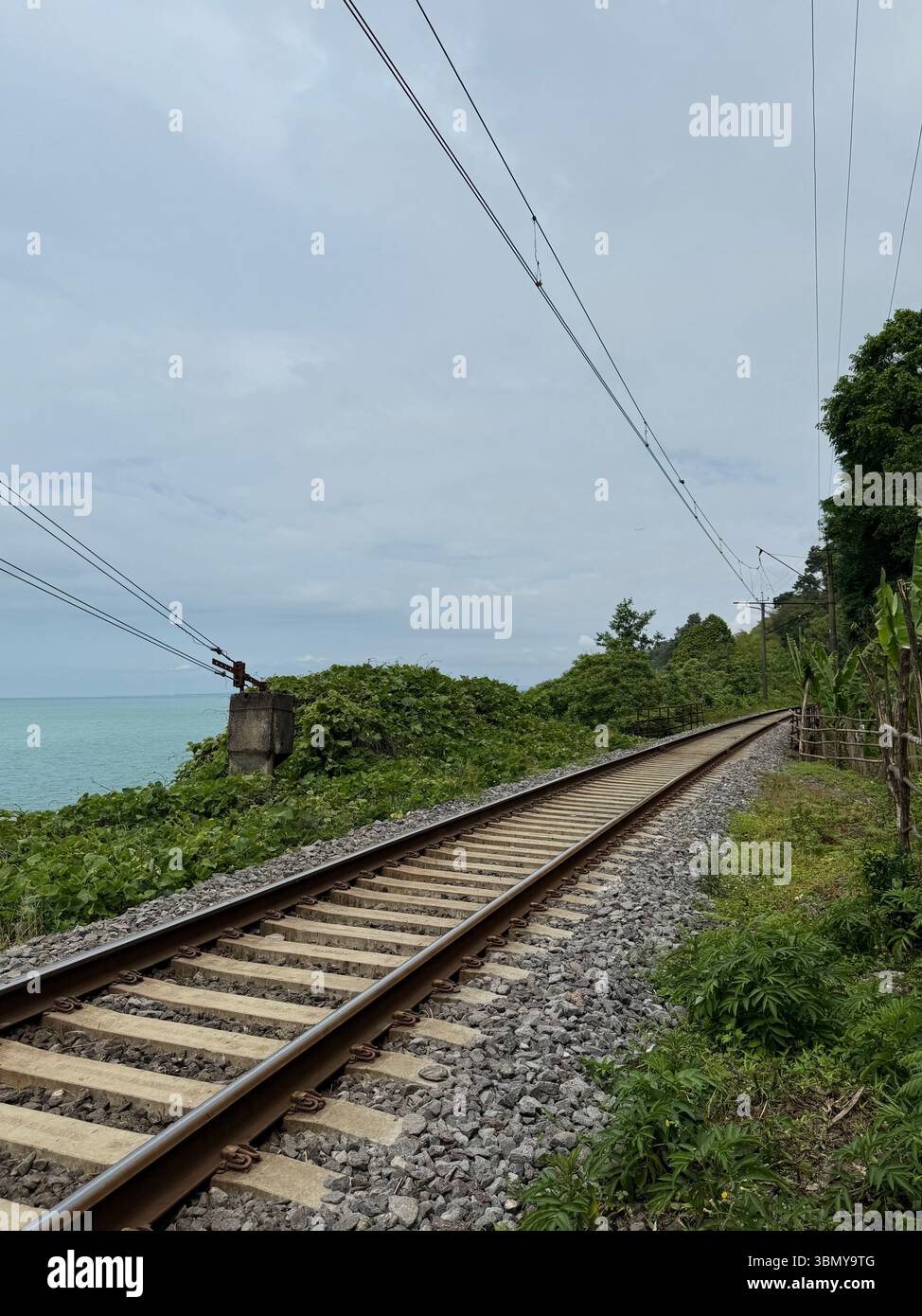 The image shows a single railway track with gravel ballast and wooden ...
