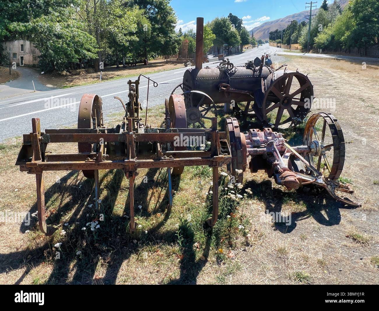 Old rusty antique Farm tractor and plough and bit of farming equipment ...