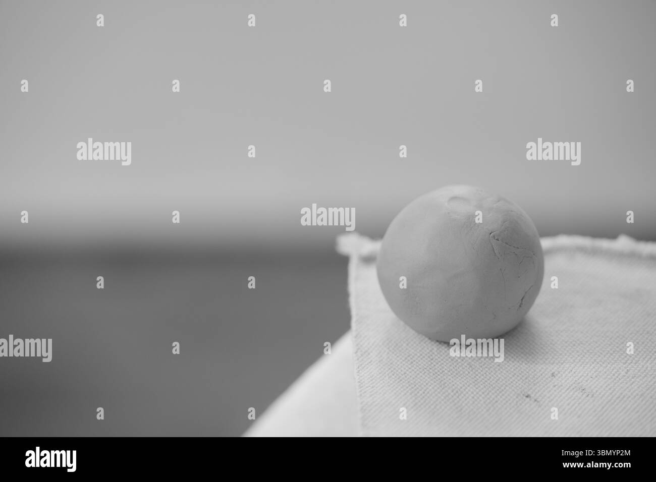 Round clay ball for pottery and sculpting on a blurred background. Raw ...