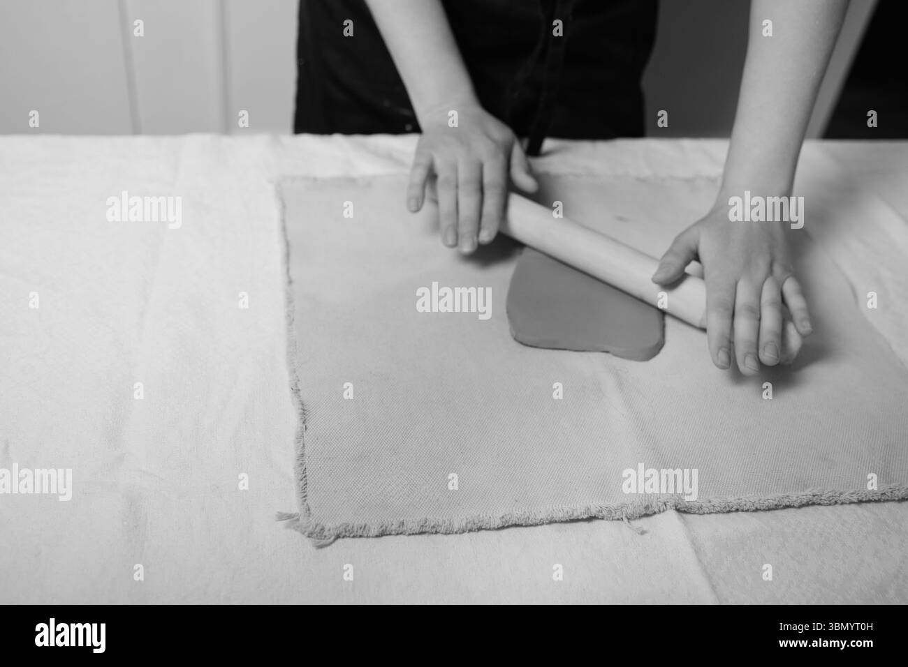 Female hands rolling clay with wooden pin in cozy pottery workshop ...