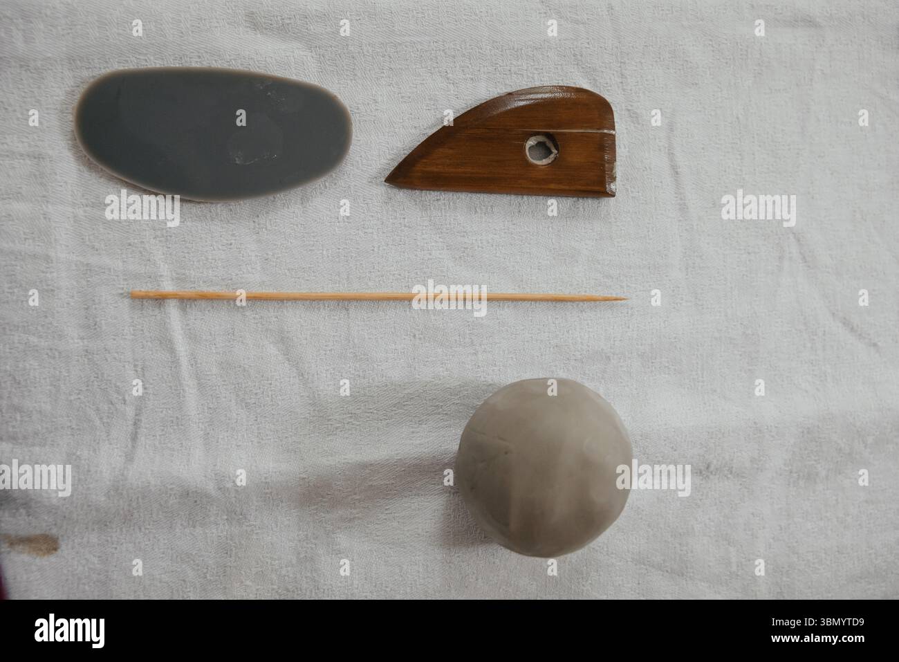 Round clay lump and ceramic hobby tools set on rustic table for pottery ...