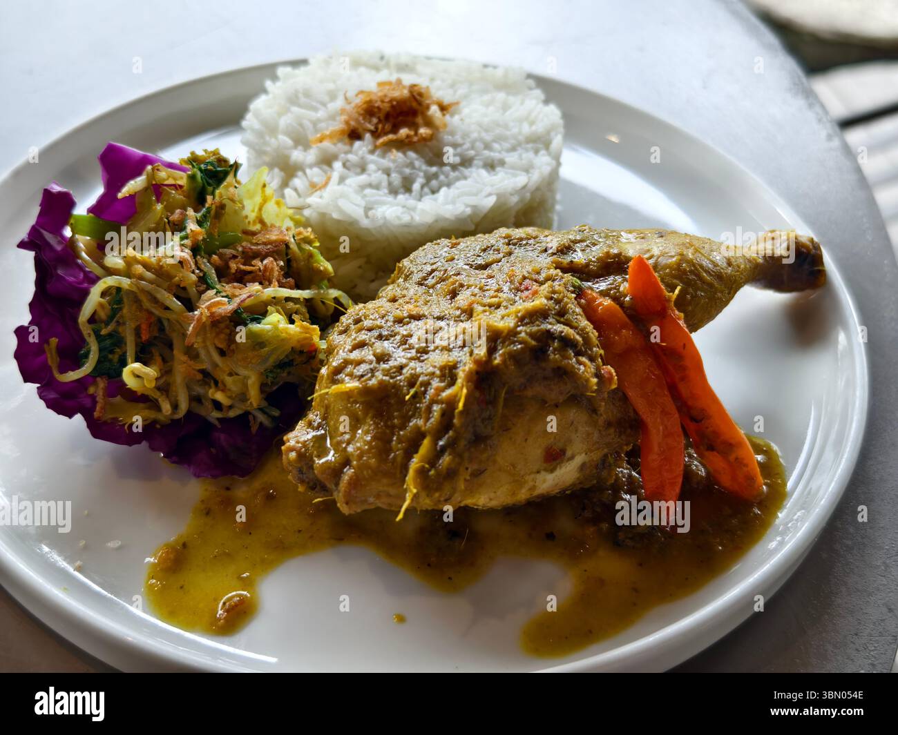 A traditional Balinese dish, Ayam Betutu, served with steamed rice ...