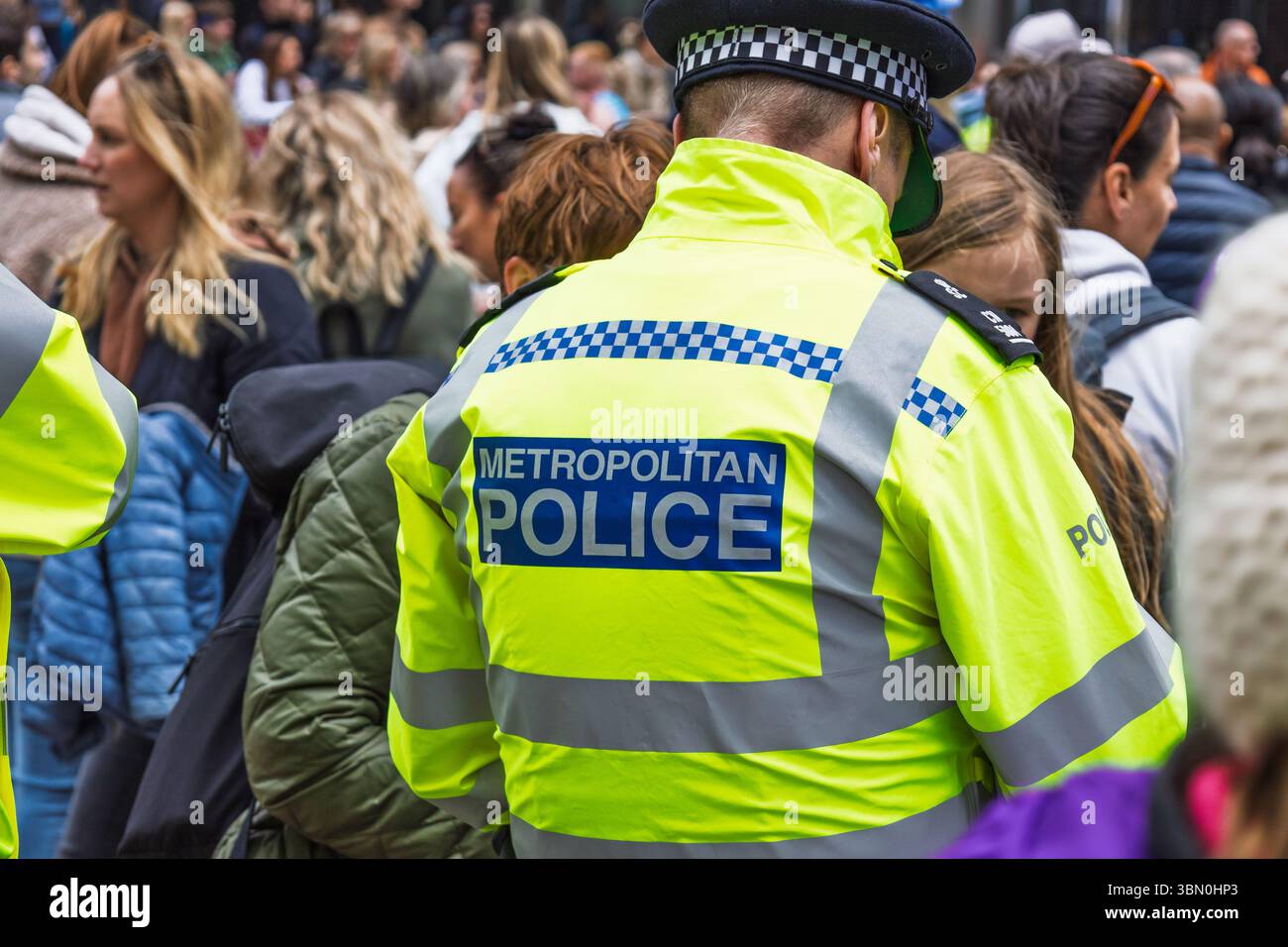 Uniformed Police Officer in Yellow Reflective Jacket Managing Crowd at ...