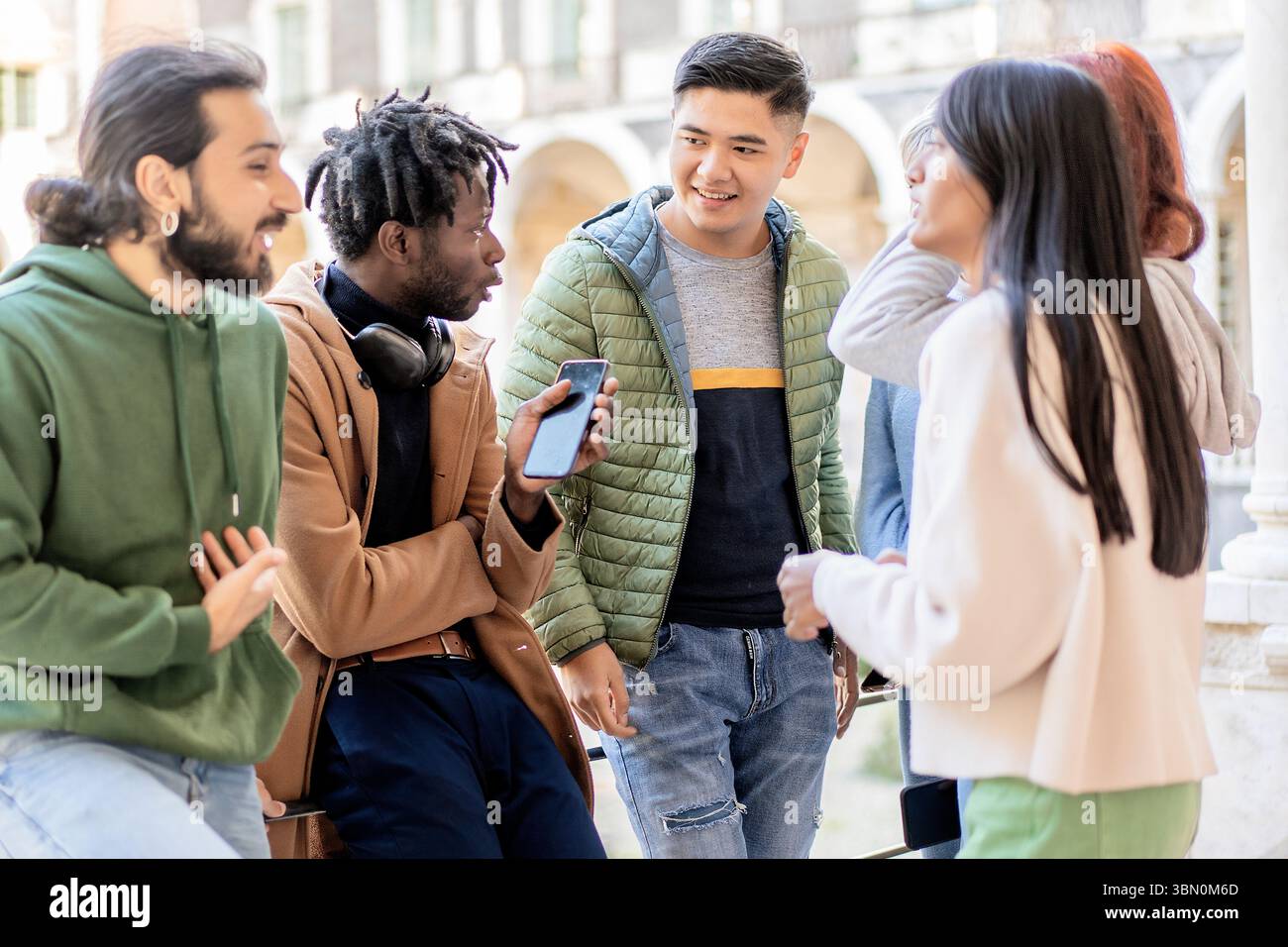 Diverse young people socializing and interacting outside in a city ...
