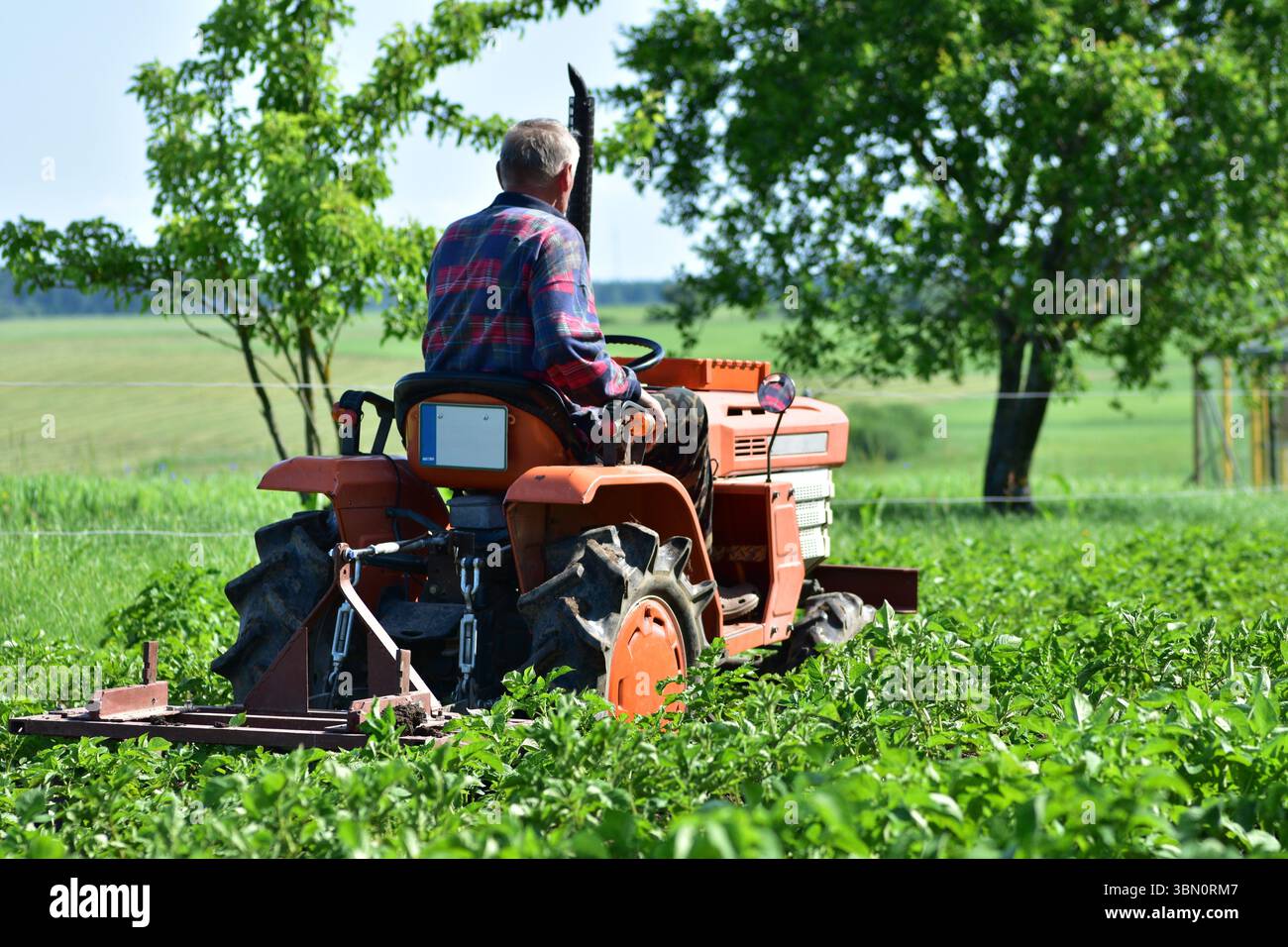 Green compact tractor working in hi-res stock photography and images ...