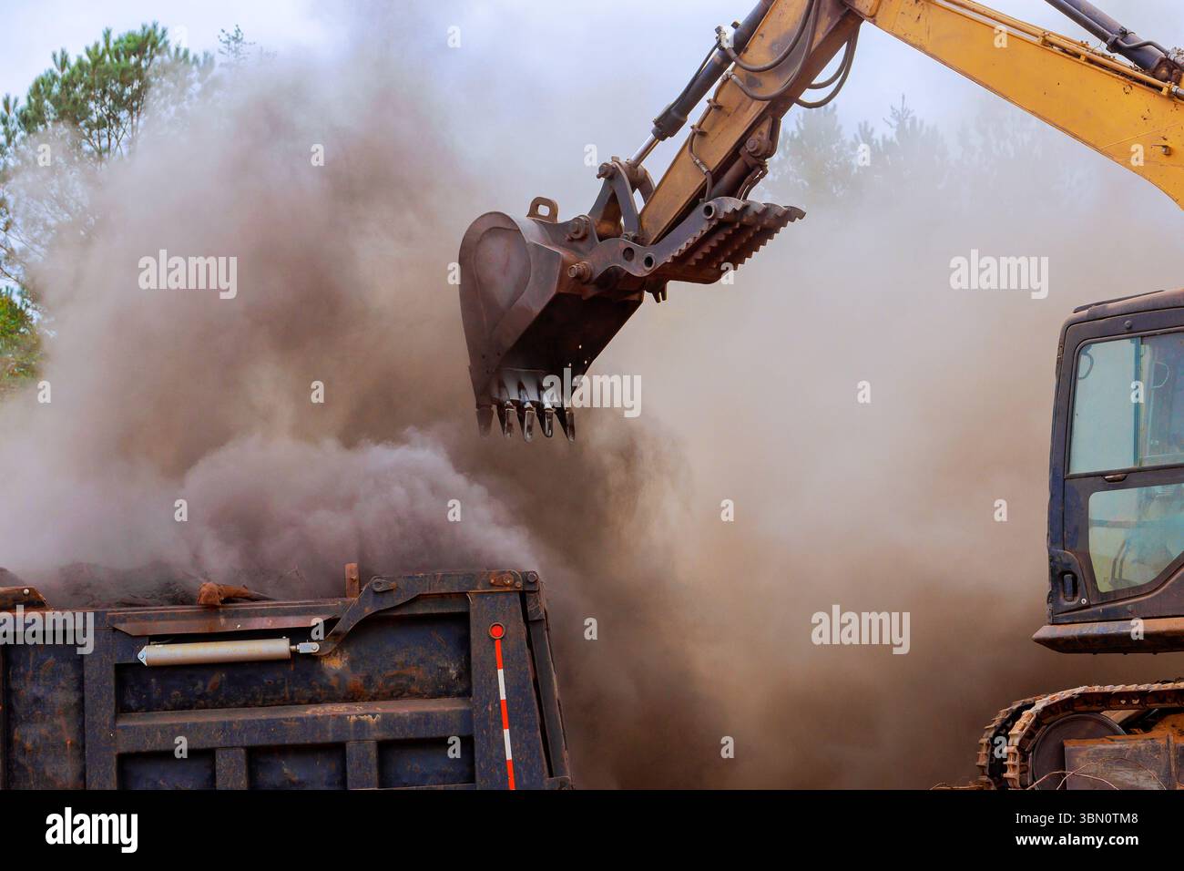 Heavy machinery operates to load construction debris into truck ...