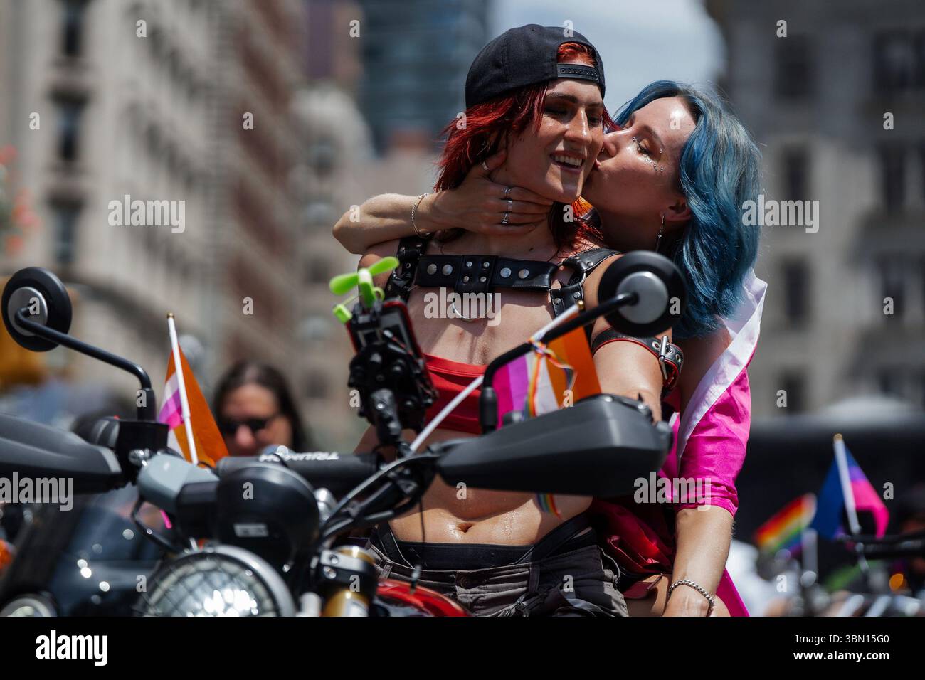 A couple embraces while riding a motorcycle during the NYC Pride March, Sunday, June 29, 2025 ...