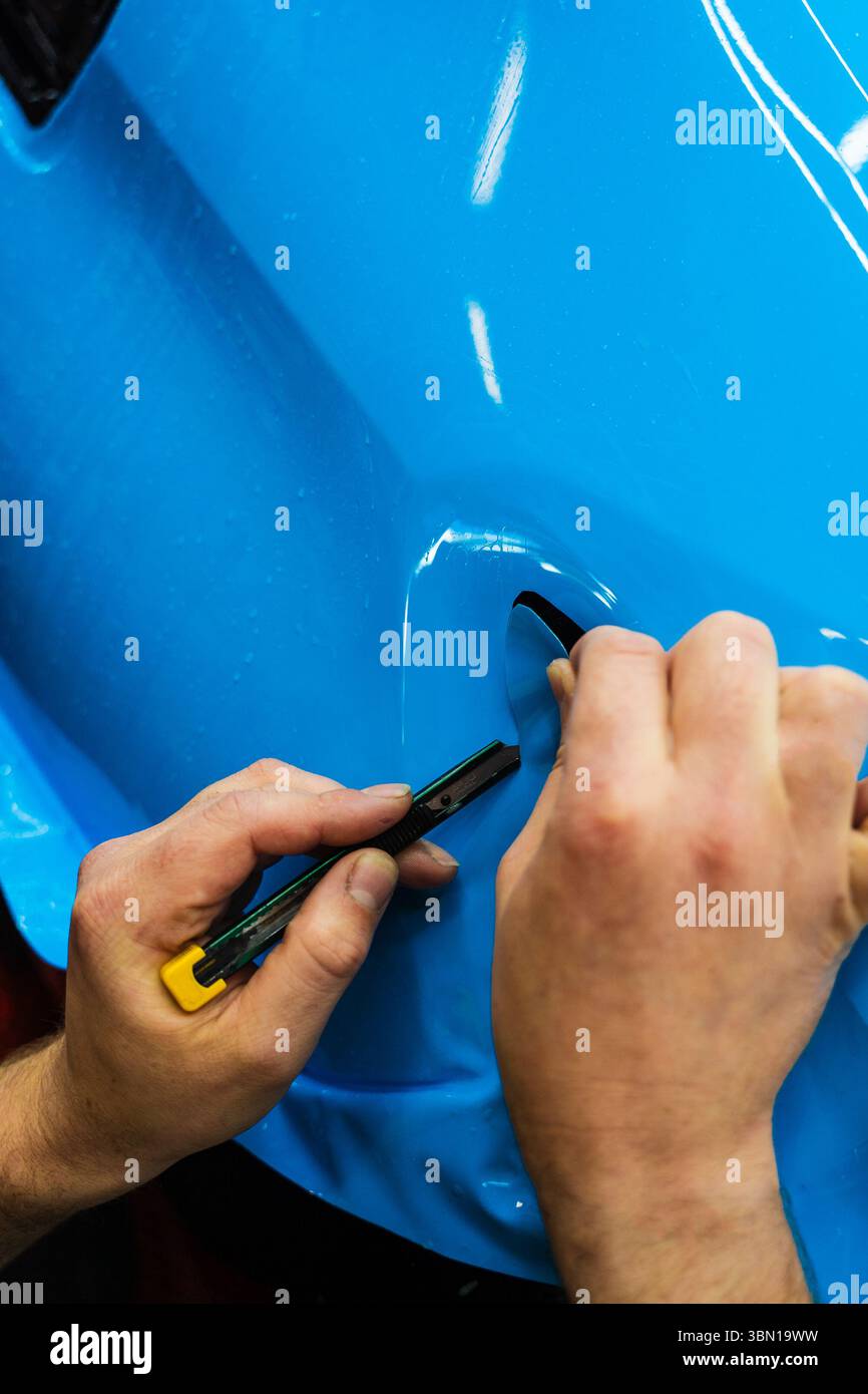 Cutting blue PPF with blade. Cutting blue paint protection film with ...